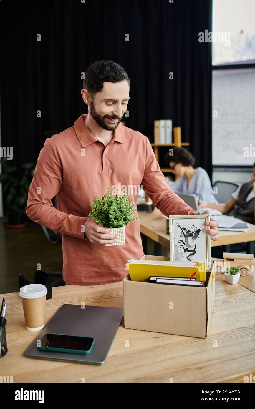 Debonair man packing his belongings during lay off in modern office ...