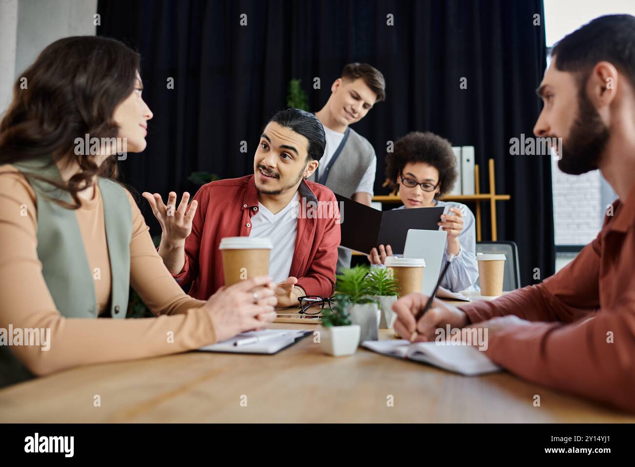 A group of colleagues discusses challenges during work process in an ...