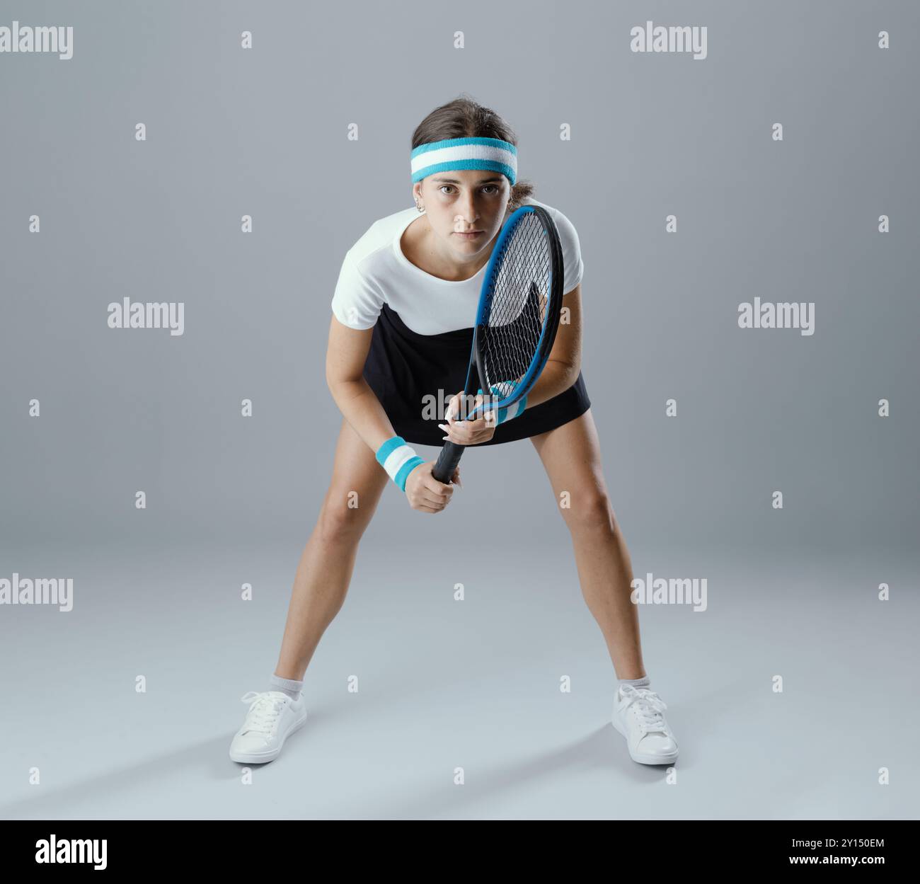 Ready focused female tennis player waiting to hit a return of serve ...