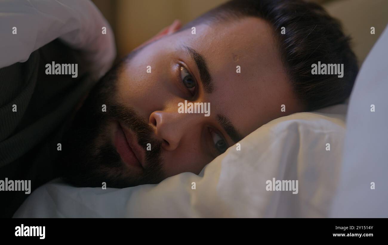 Caucasian man lying on bed trying sleep awake insomnia male guy late ...