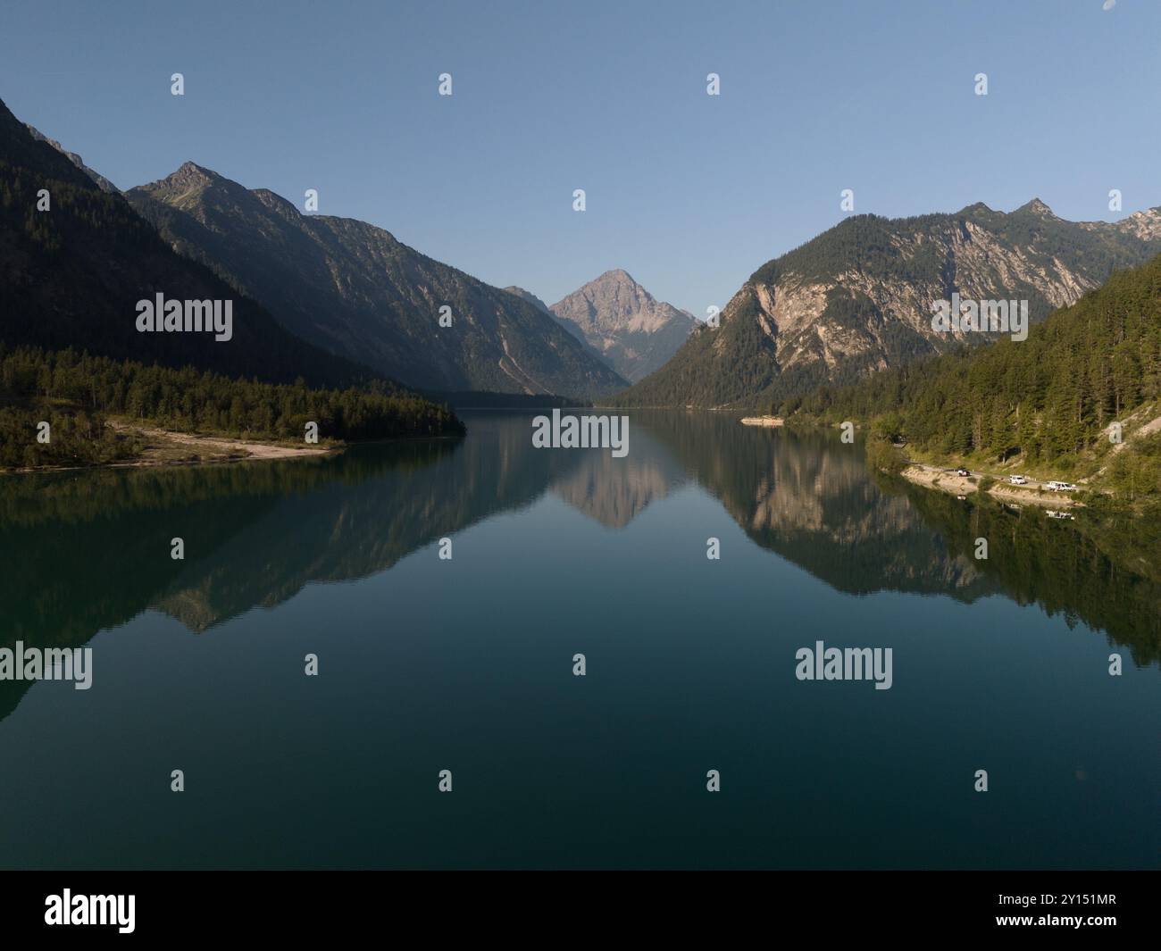 The tranquil waters of Plansee Austria reflect the surrounding mountain ...