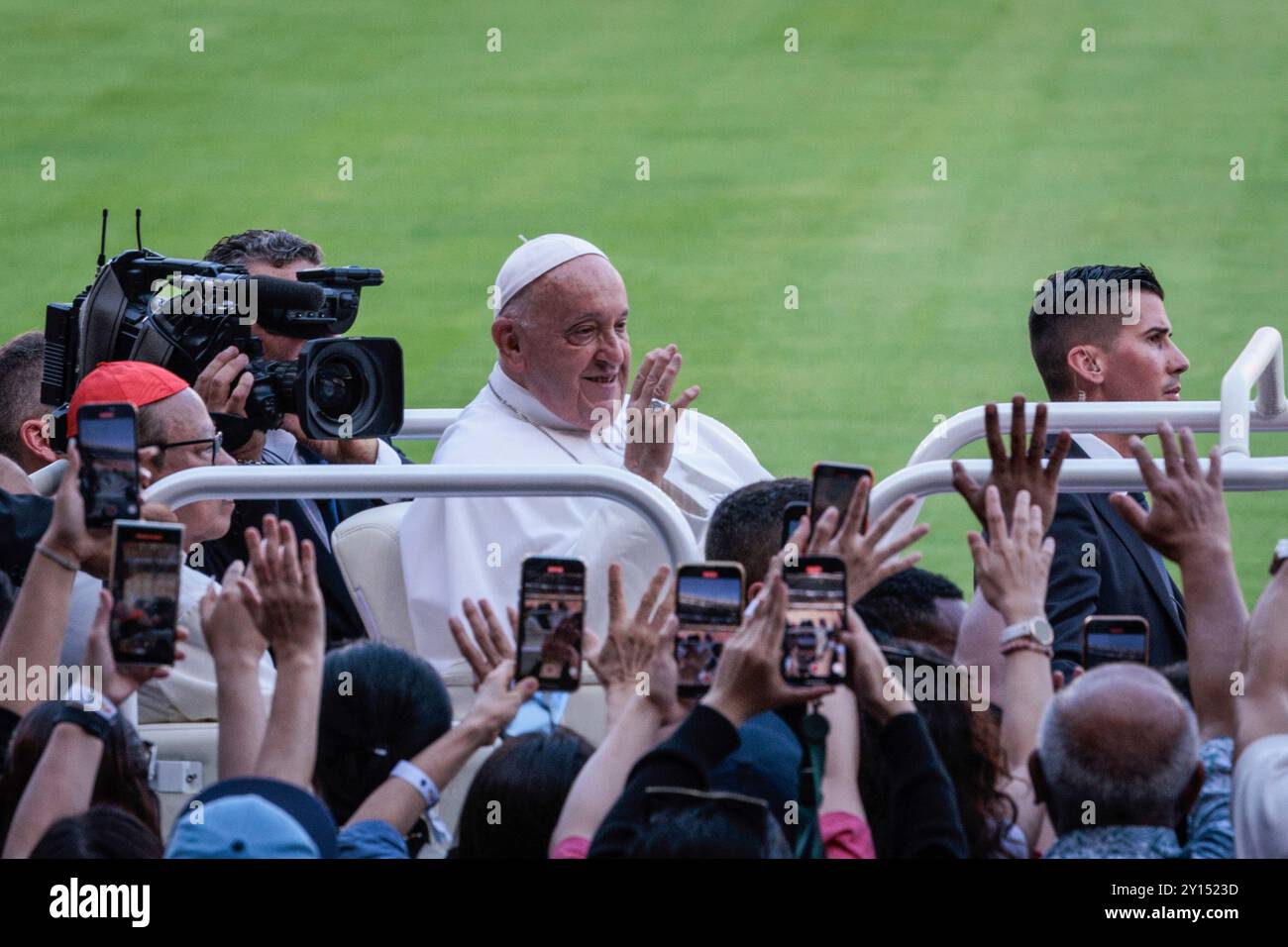 Pope Francis waves from a car as he arrives for a holy mass at the ...