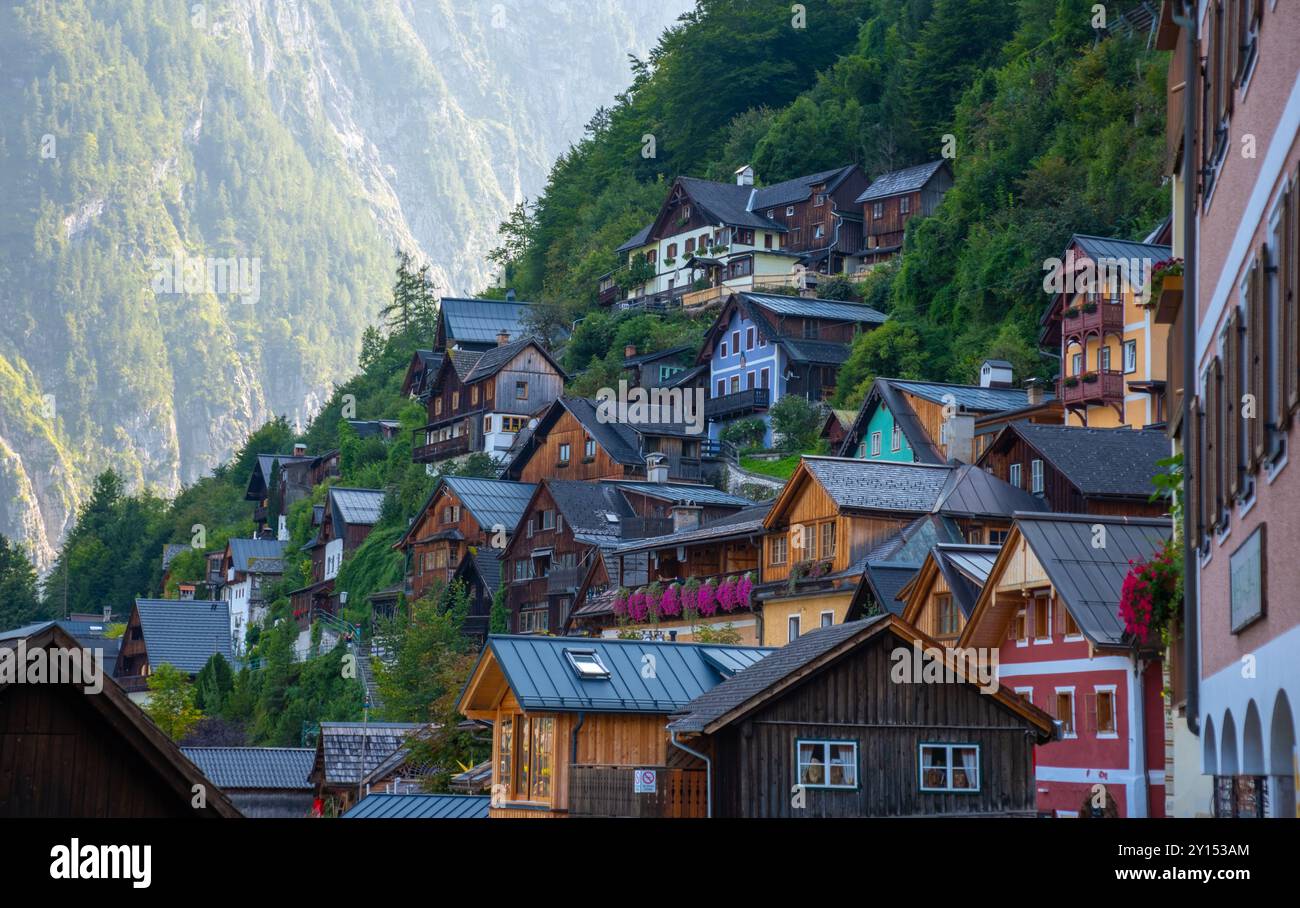 Nestled against the stunning mountains of Hallstatt, Austria, colorful ...