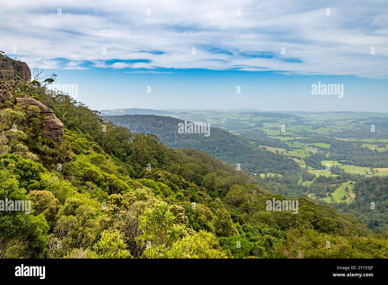 A panoramic view of a lush green valley with rolling hills and trees ...