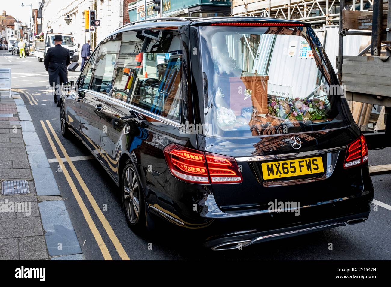 A Funeral Director Walks In Front Of A Black Hearse, High Street, Lewes ...