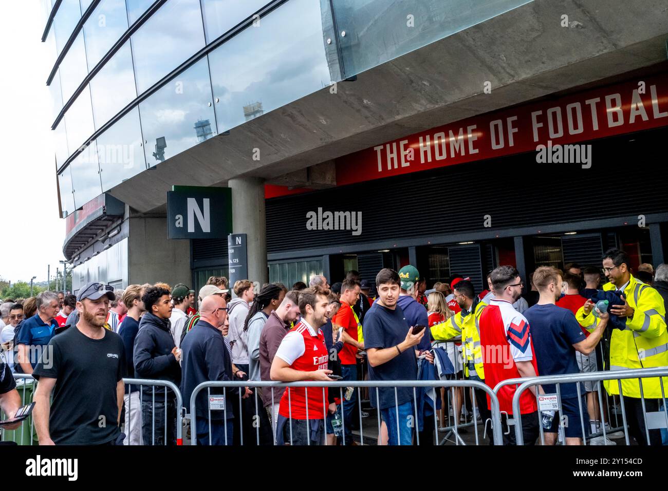 Arsenal Football Fans Queue For A Security Check Before Entering The ...