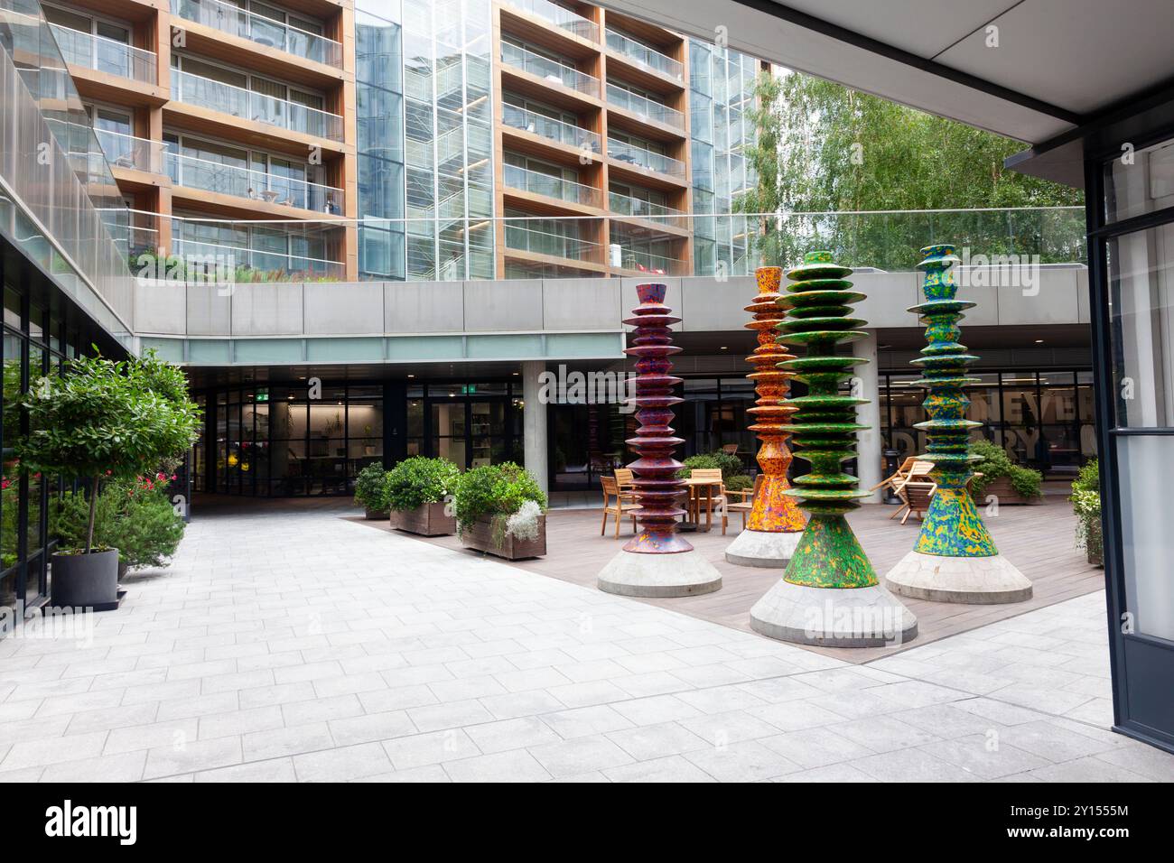 Colourful decorative street furniture, in a courtyard of a mixed use ...