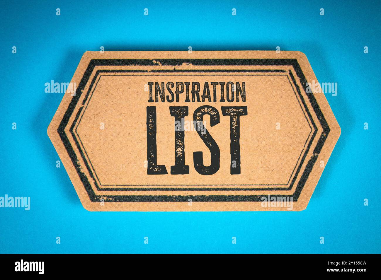 INSPIRATION LIST. Cardboard sticker with text on a blue background ...
