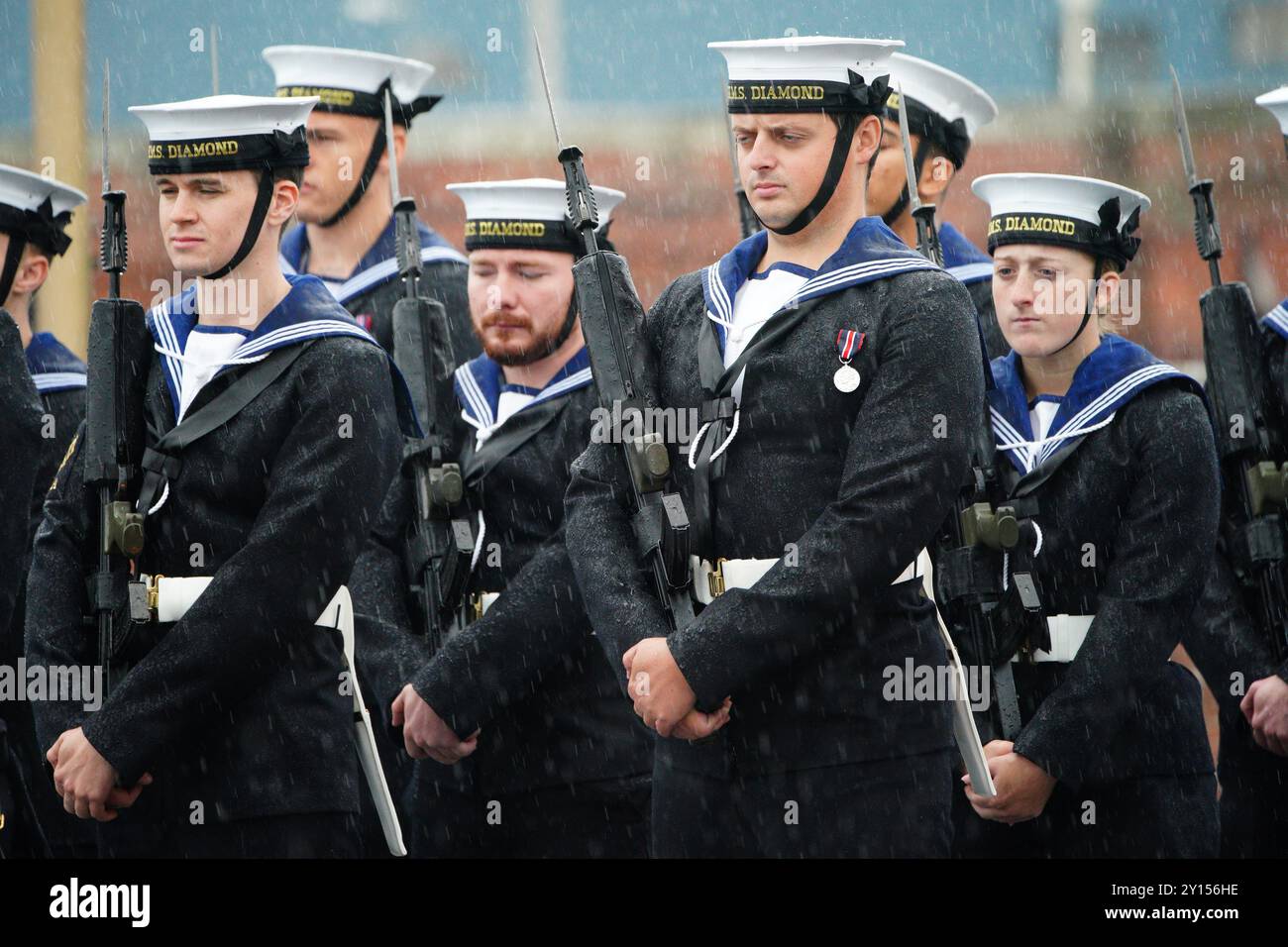 Royal Navy crew from HMS Diamond stand on parade in the rain ahead of a ...