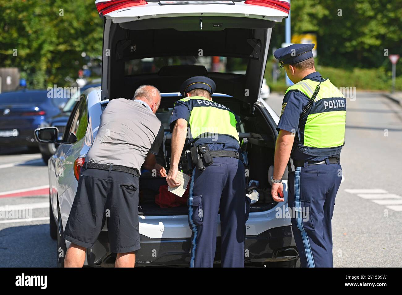 Police officers check the trunk of a car. Border police officers check ...