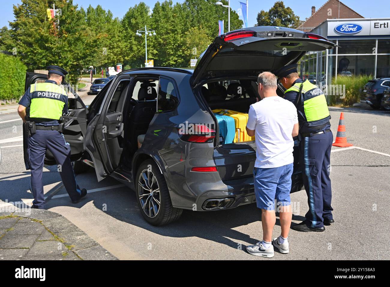 Police officers check the trunk of a car. Border police officers check ...