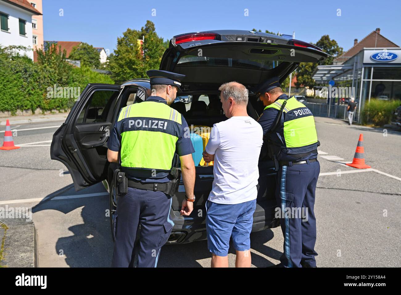 Police officers check the trunk of a car. Border police officers check ...