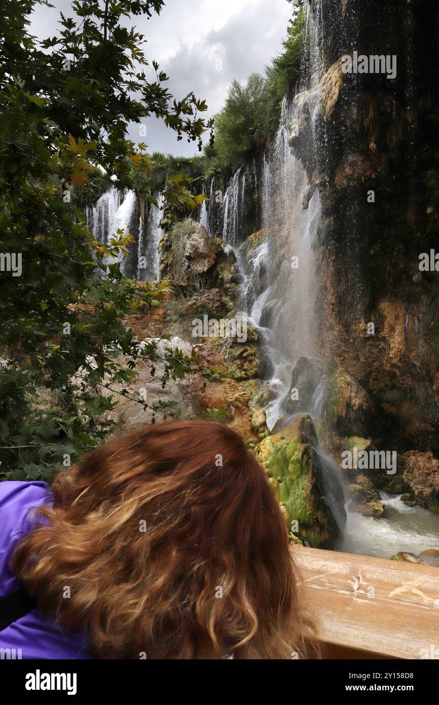 Blonde woman watching waterfall. Nature background Stock Photo - Alamy