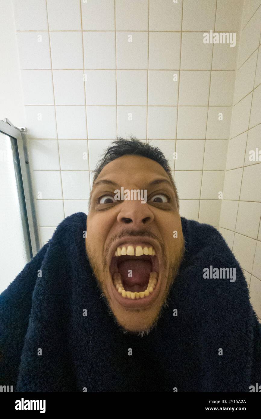 A man with a big smile on his face and his mouth wide open. He is ...