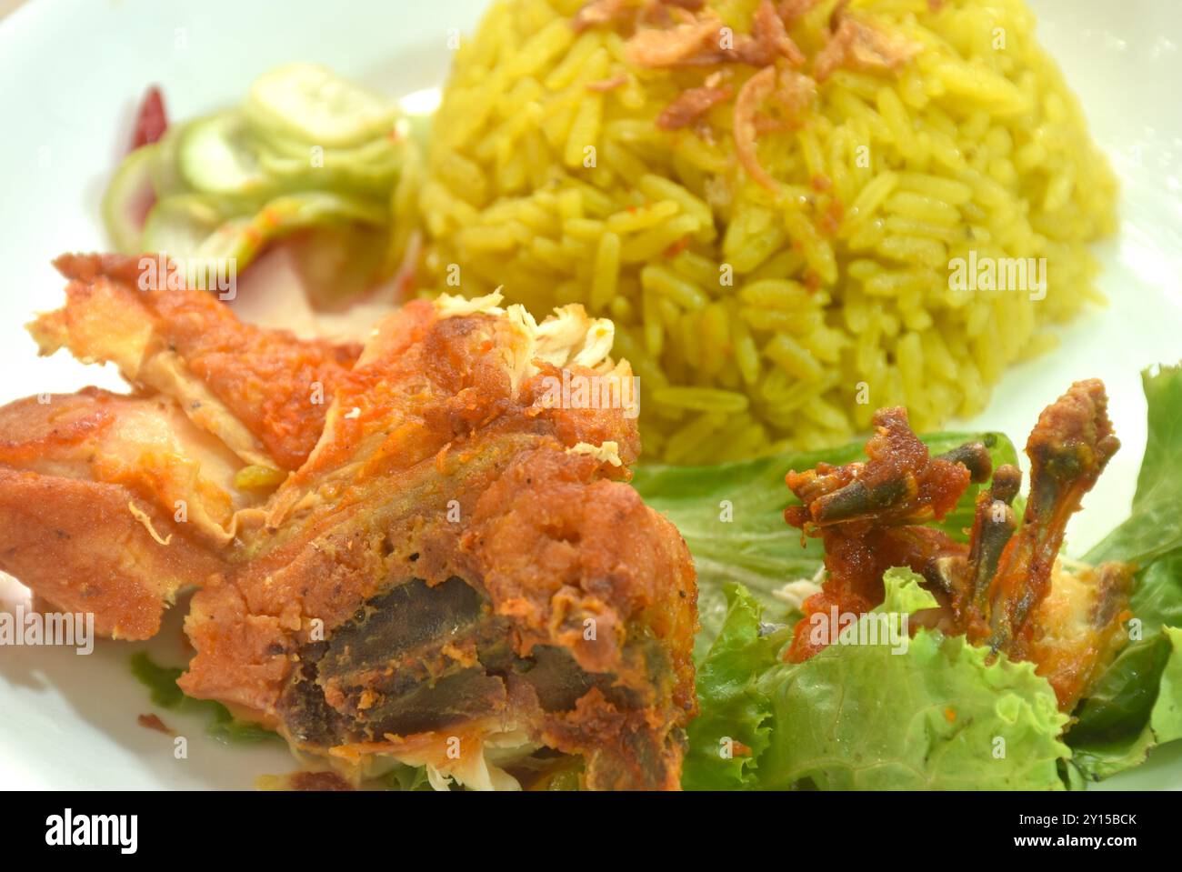 chop fried chicken and biryani rice cooked with curry on plate dipping ...