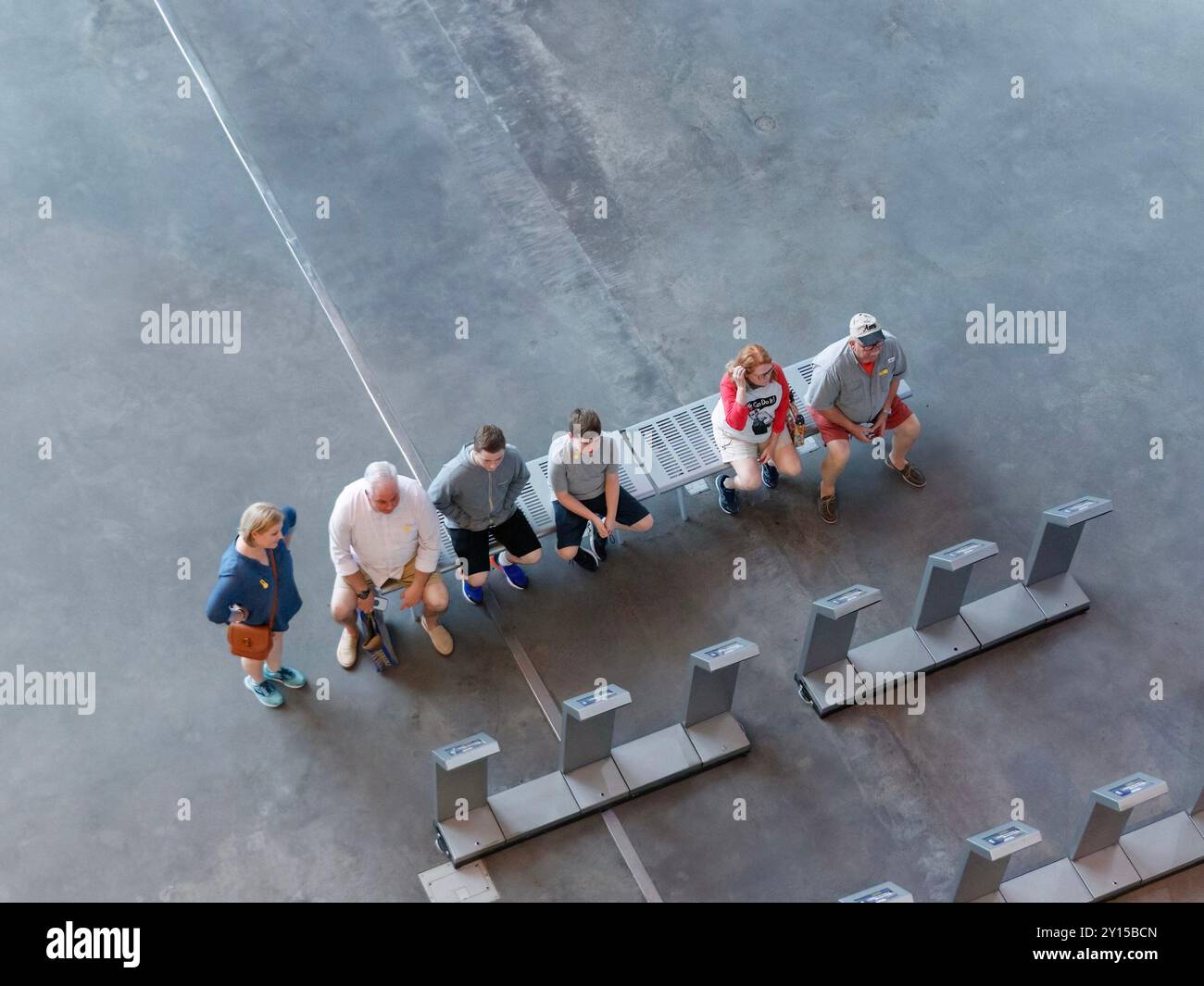 Aerial view of six people sitting and waitingin an exhibition museum ...