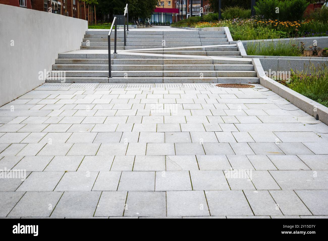 Tiled pedestrian pathway with steps within urban surroundings Stock ...
