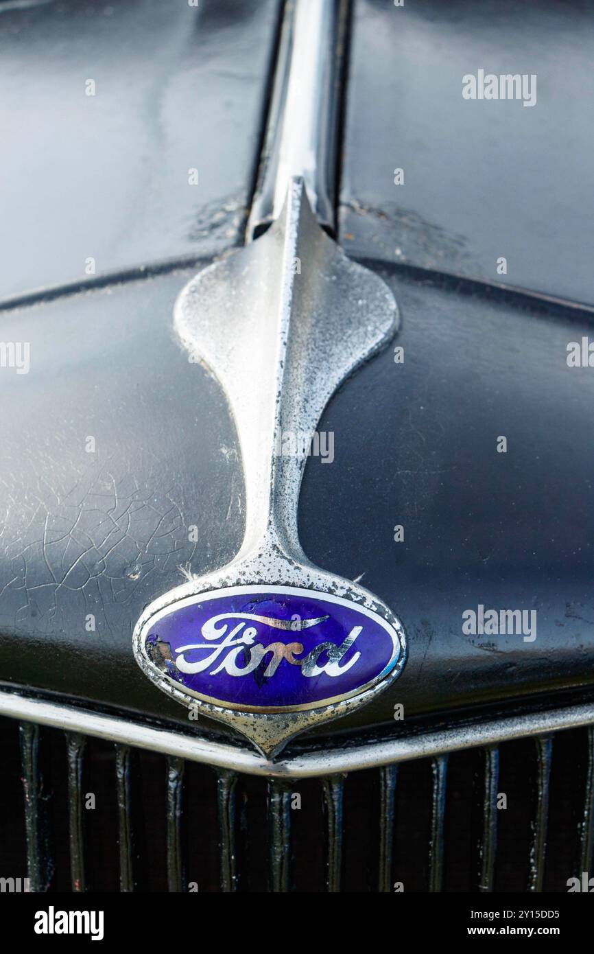 Close-up view of a vintage black Ford car hood logo, displaying the ...