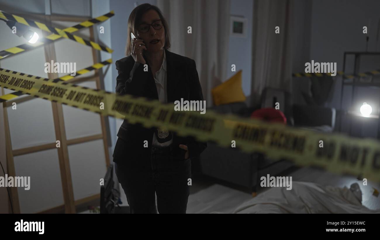 A middle-aged woman detective in a blazer speaks on a phone at an ...