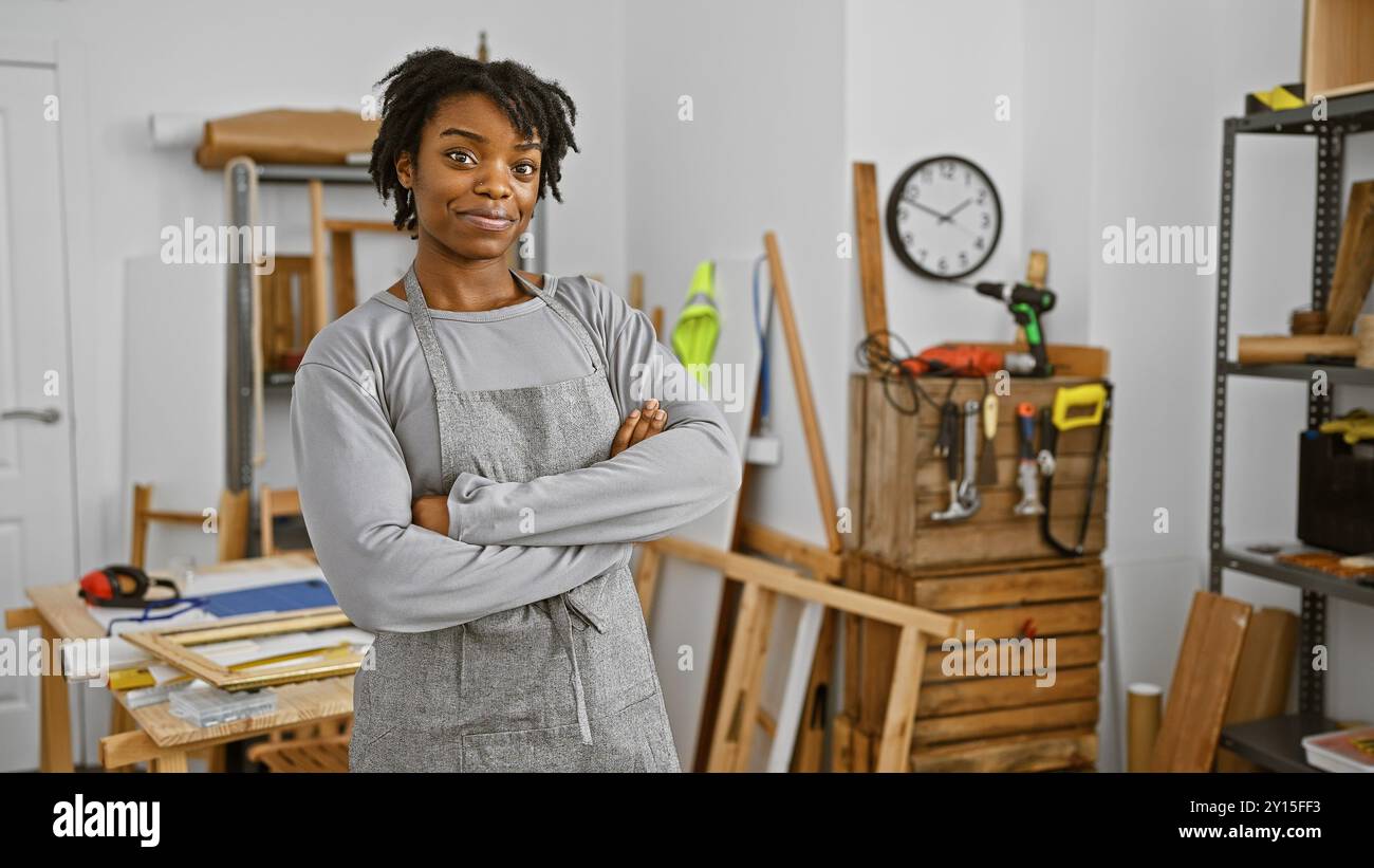 Confident woman with dreadlocks stands arms crossed in a well-equipped ...