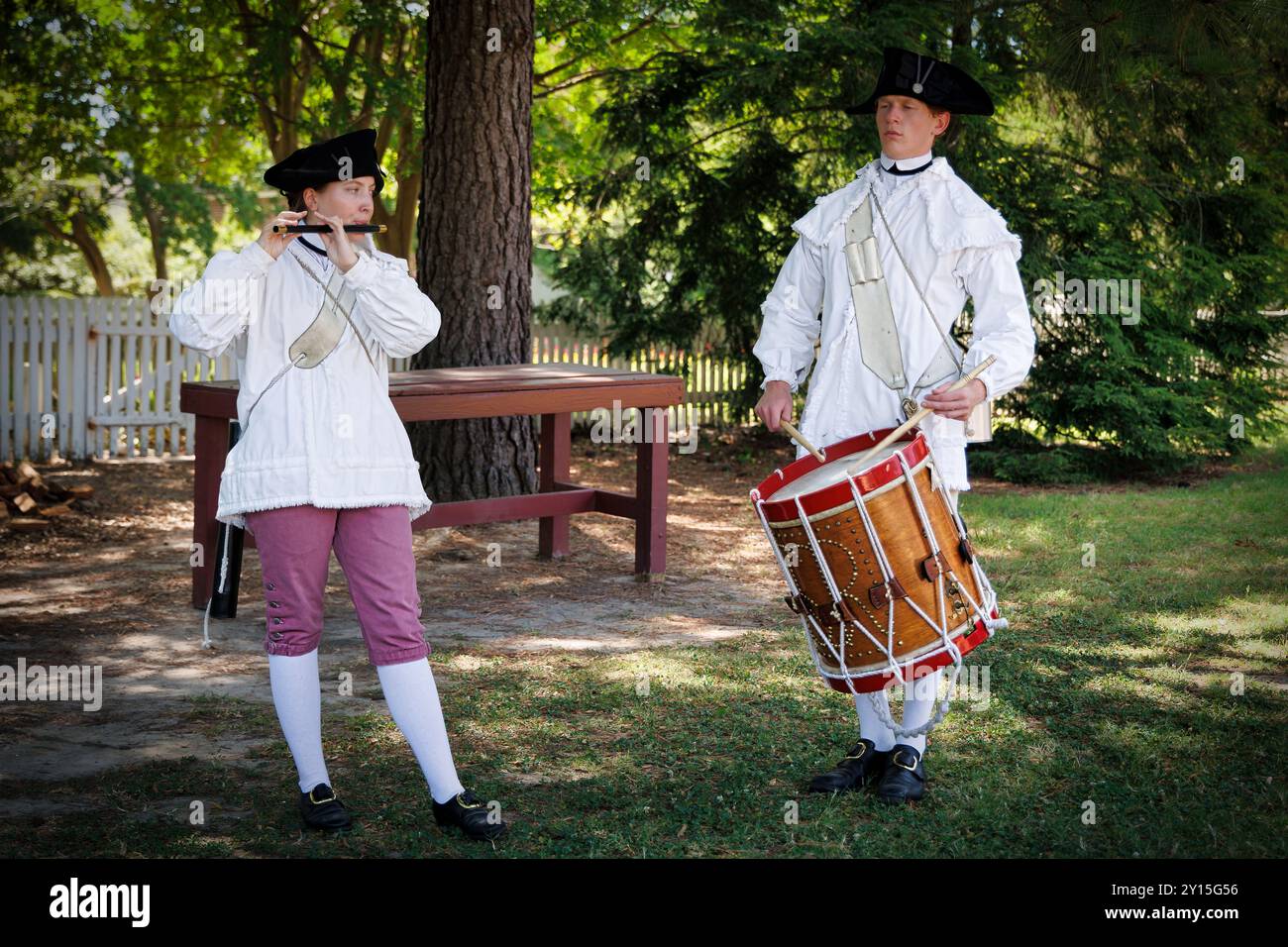 A fife and drum duo performs under the shade of the trees at Colonial ...