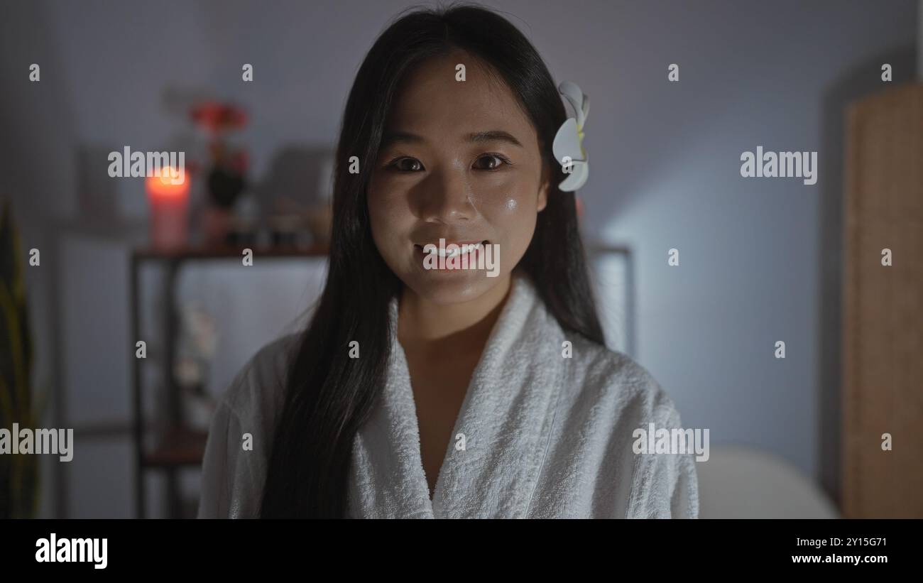 Beautiful young chinese woman in a spa room wearing a white robe and a ...