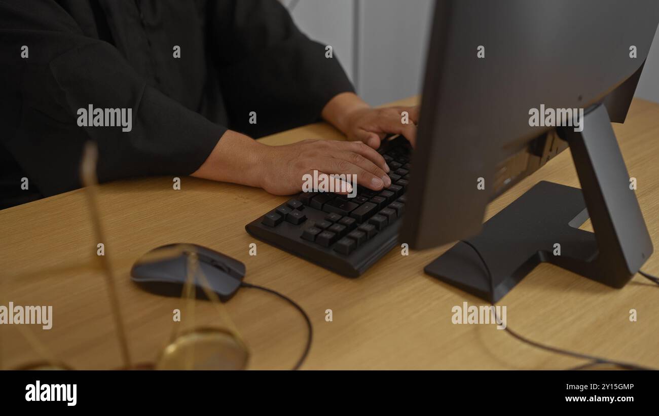 Judge hands typing on a keyboard in an office setting, with scales of ...