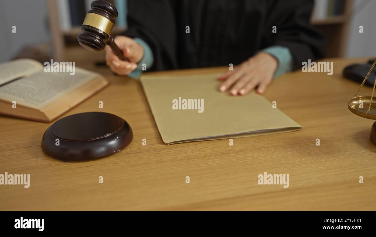 Woman judge hitting gavel on desk in courtroom while examining ...