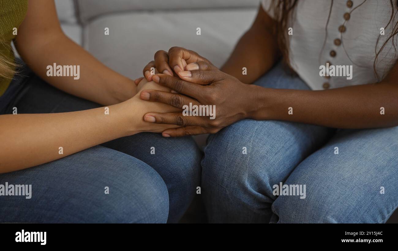 Women friends sitting together indoors in a home living room holding ...