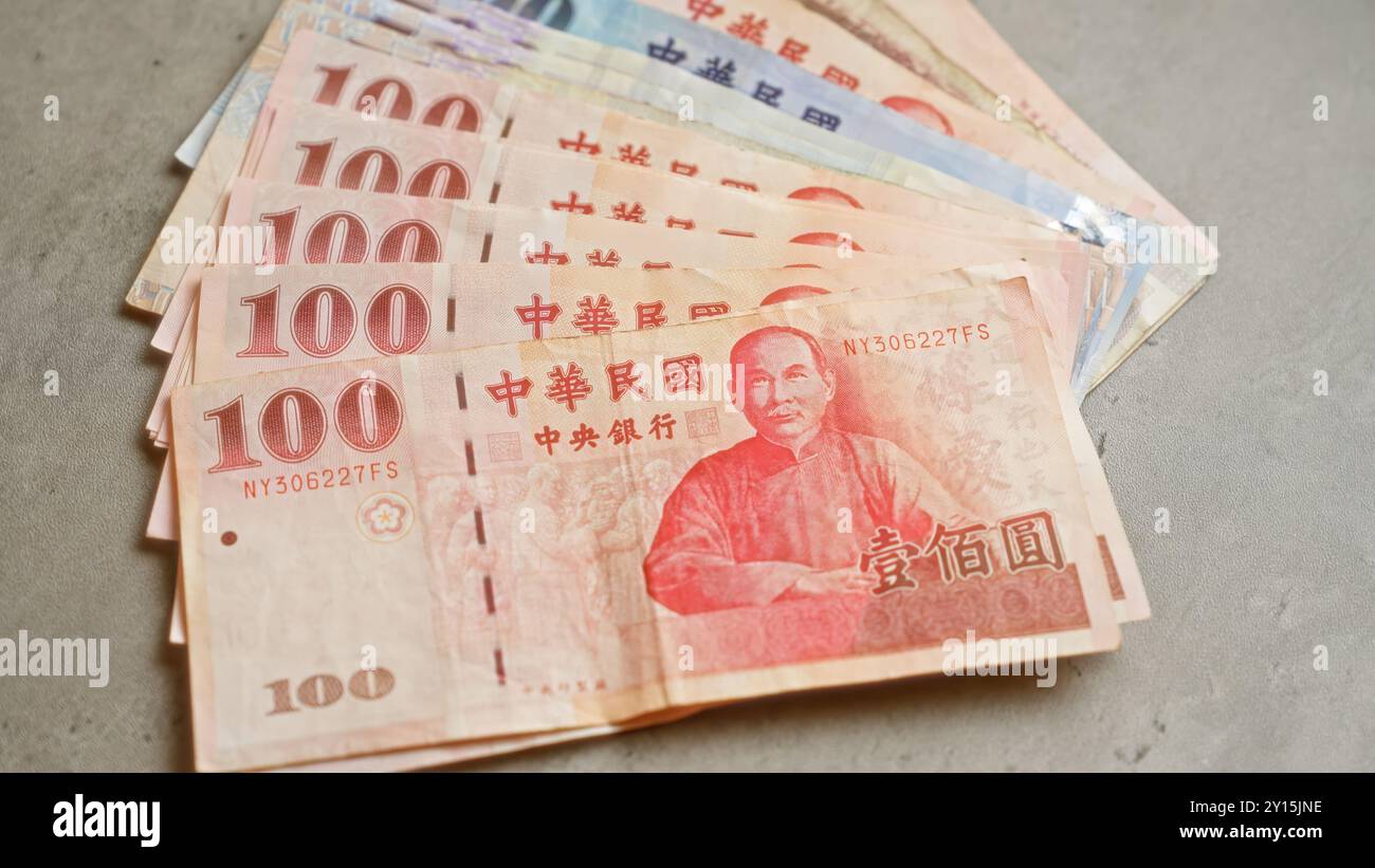 Chinese yuan banknotes spread out on a concrete surface, showcasing the ...