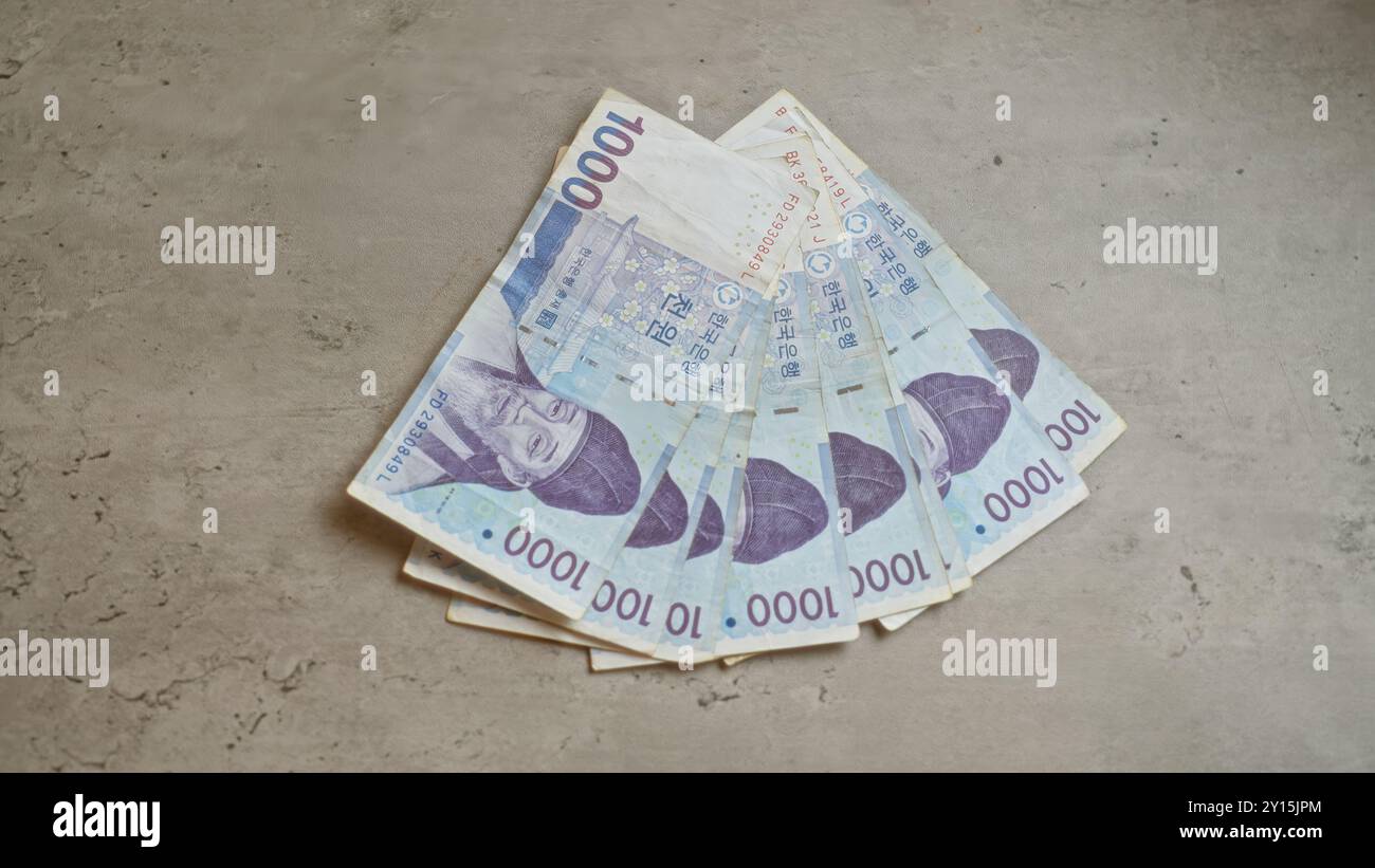 South korean won banknotes spread out on a concrete surface ...