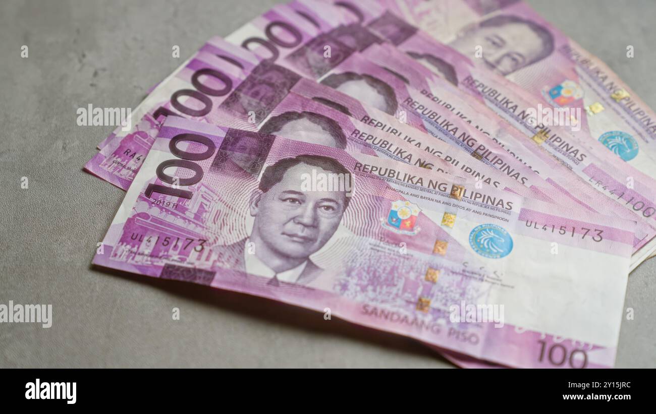 Philippine pesos banknotes on a concrete surface showcasing 100 peso ...