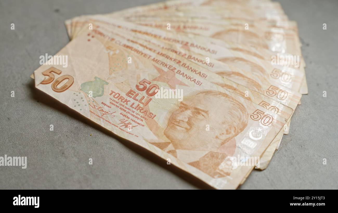 Turkish fifty lira banknotes fanned out on a concrete surface, showing ...