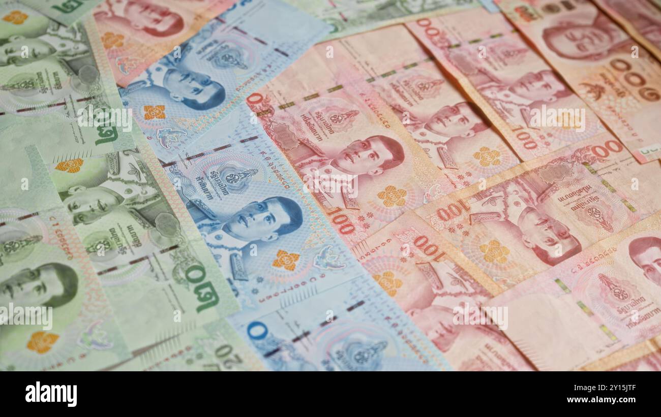 Variety of colorful thai baht banknotes spread out, showcasing multiple ...