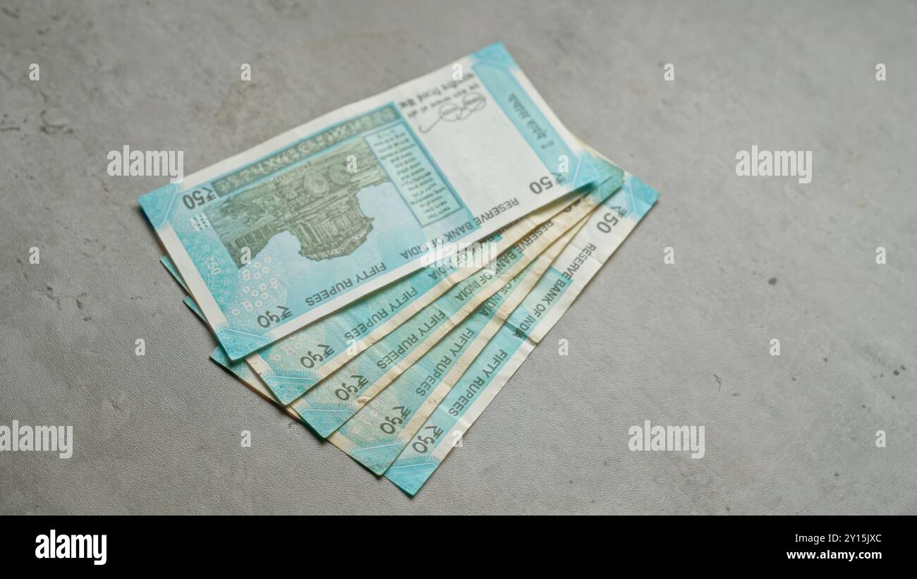 Indian fifty rupee banknotes on a concrete surface, depicting currency ...