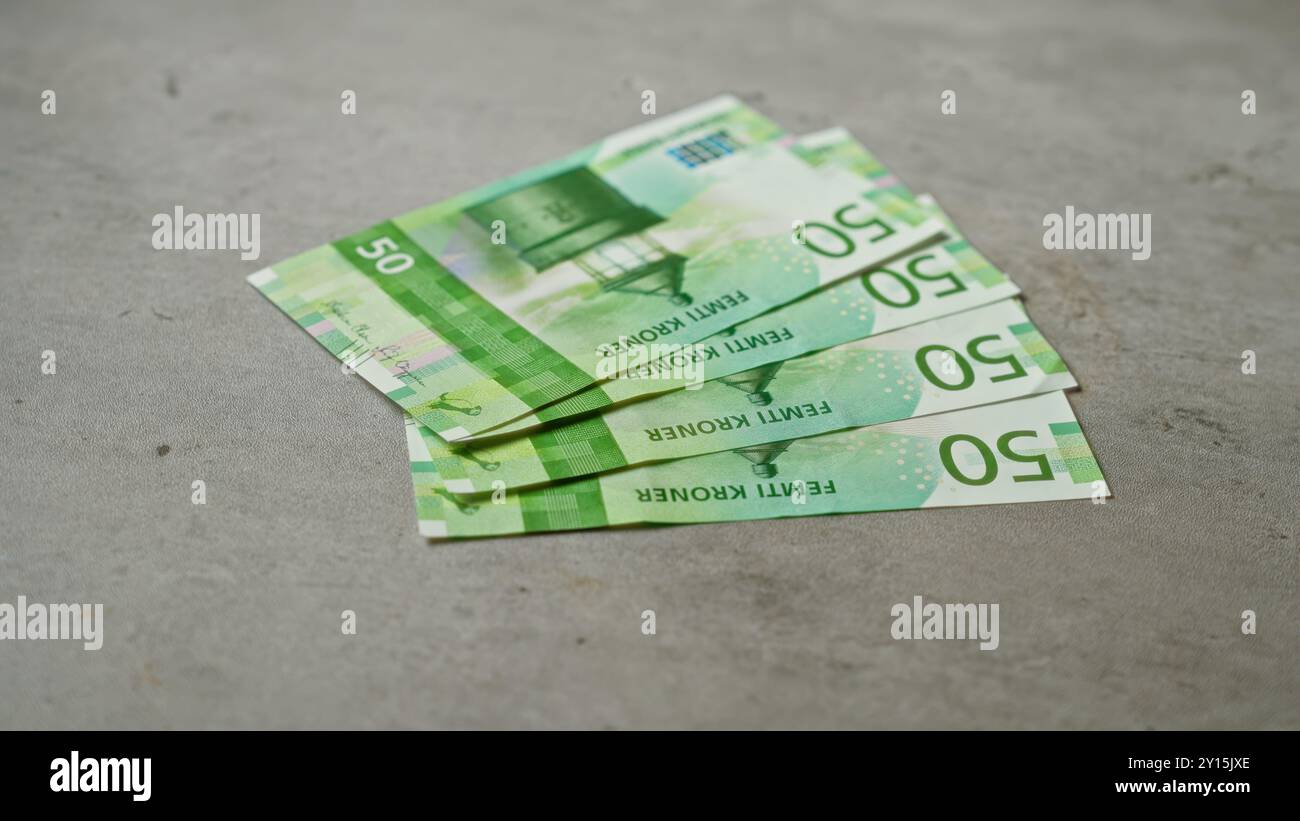Norwegian banknotes of fifty kroner displayed on a concrete surface ...