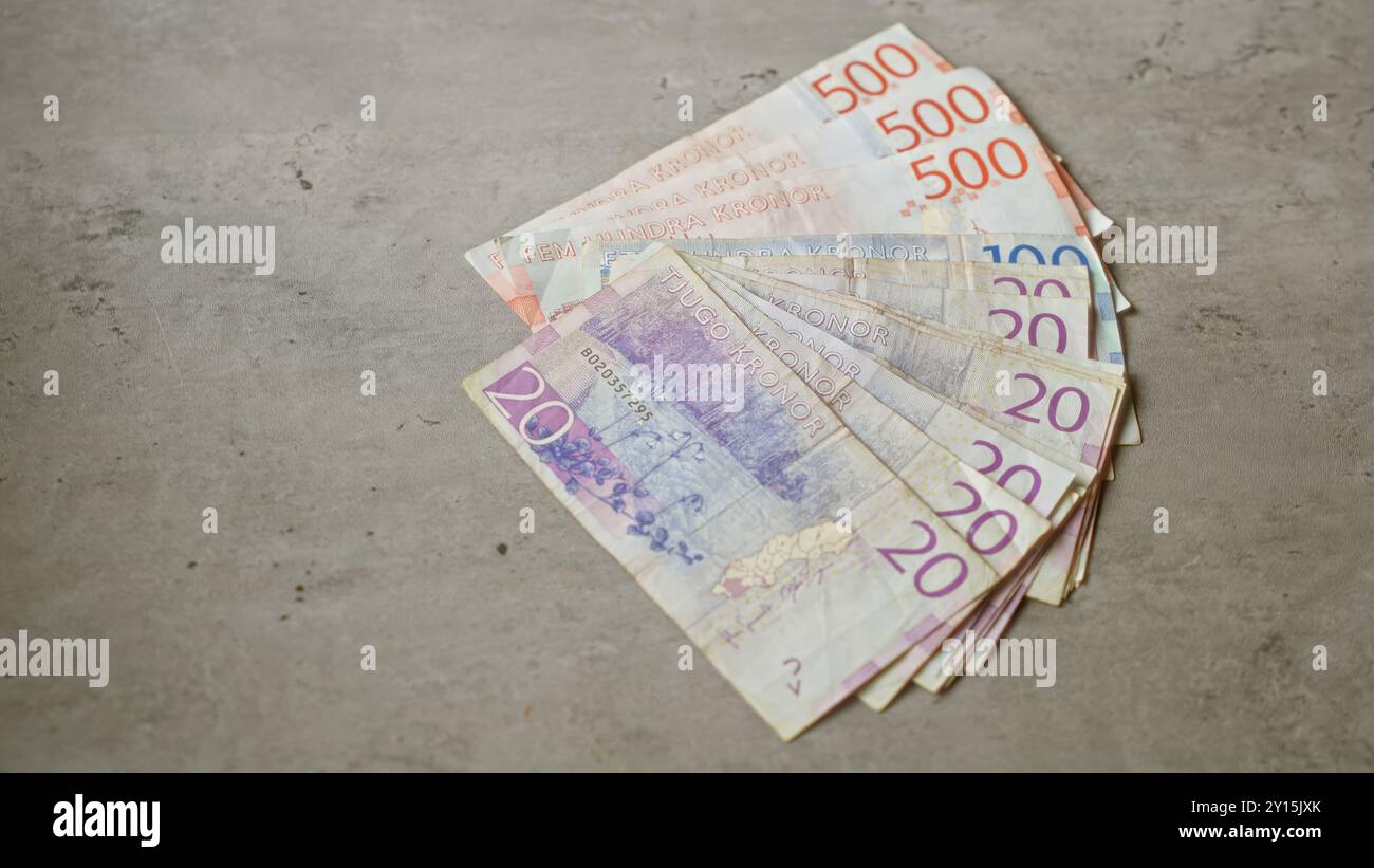 Swedish banknotes in various denominations spread out on a concrete ...