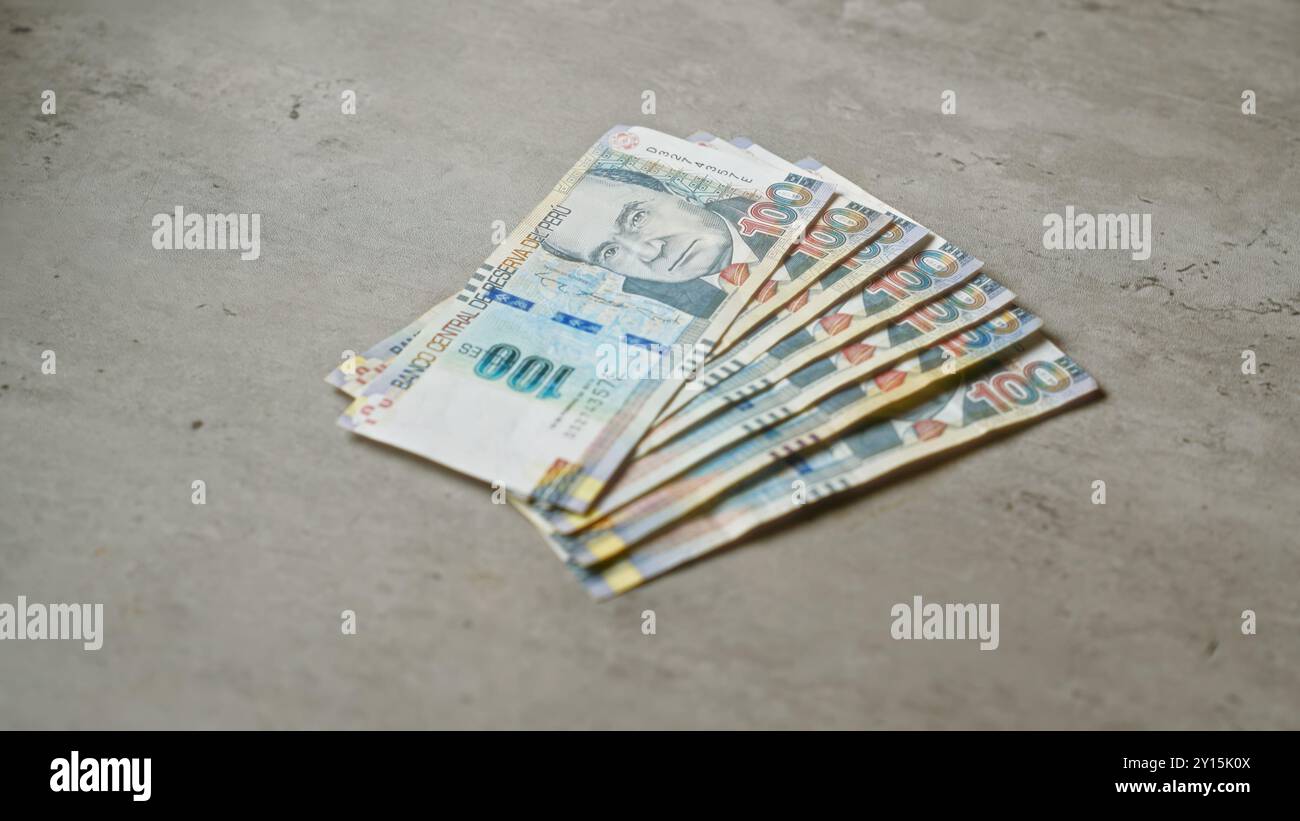 Peruvian banknotes in soles currency arranged on a concrete surface ...