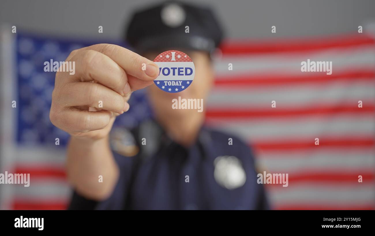 Close-up of a uniformed female officer holding an 'i voted' sticker ...