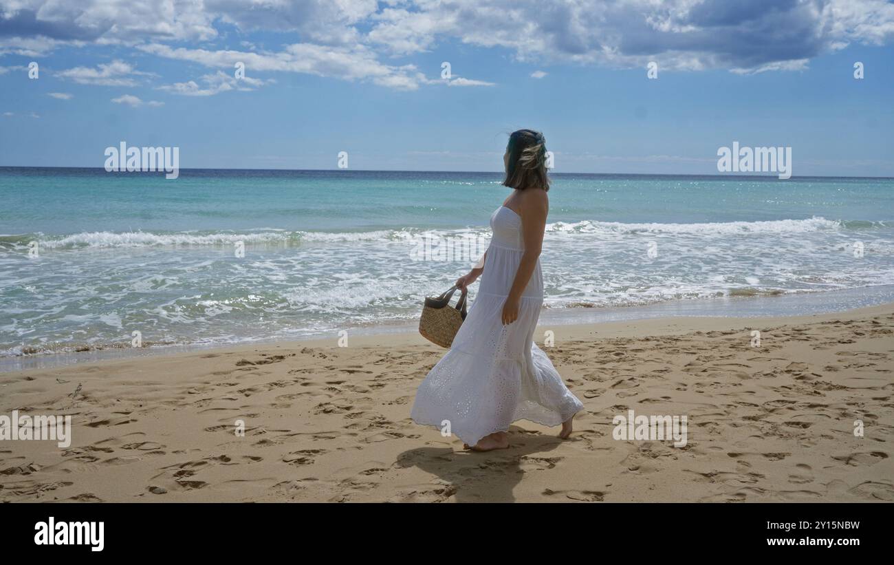 A beautiful young hispanic woman strolls along the stunning beach of ...