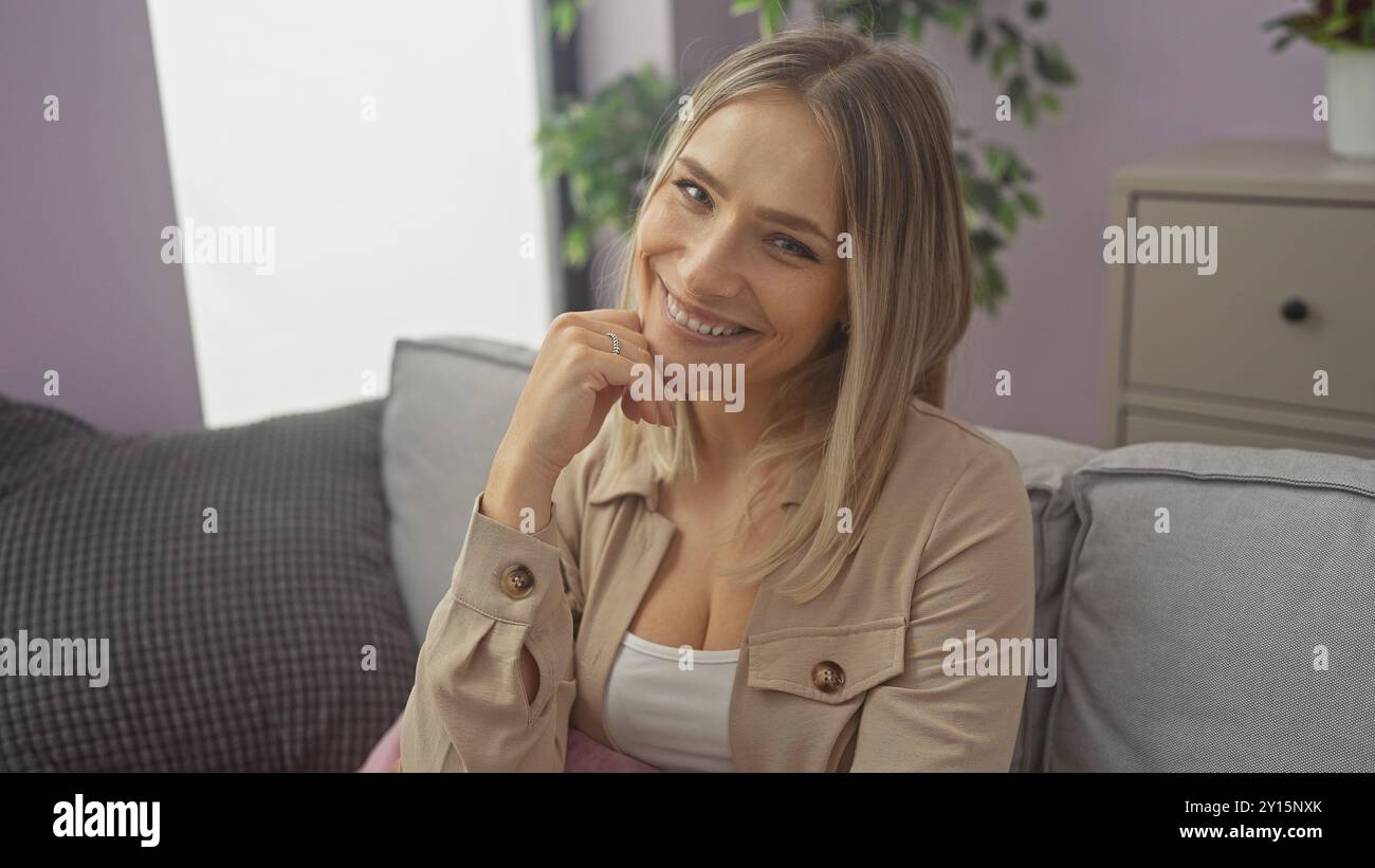A beautiful blonde woman smiles warmly while relaxing in her cozy ...
