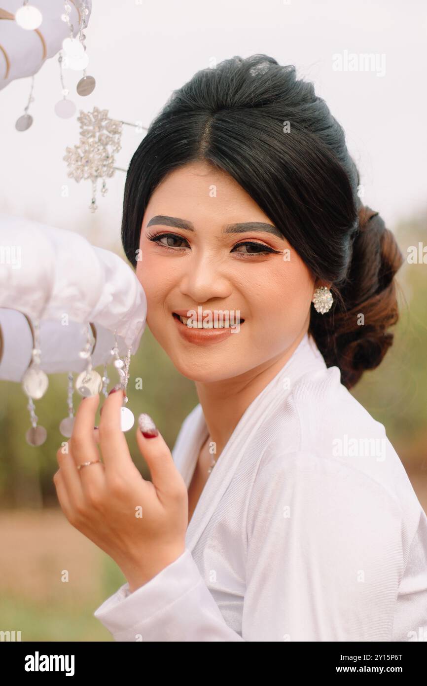 Charming young indonesia woman standing smiling at the camera wearing ...