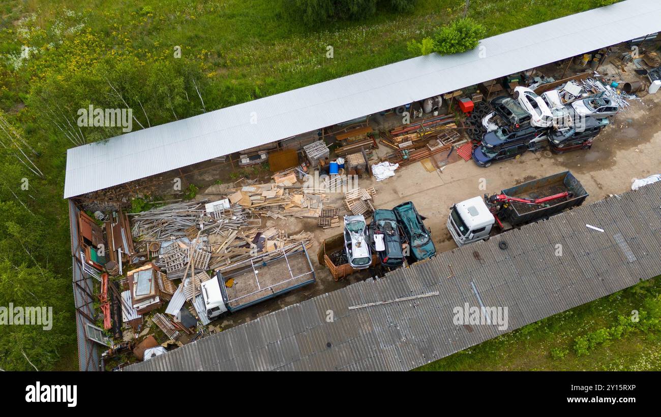 An aerial view of a vehicle junkyard with various dismantled cars and ...