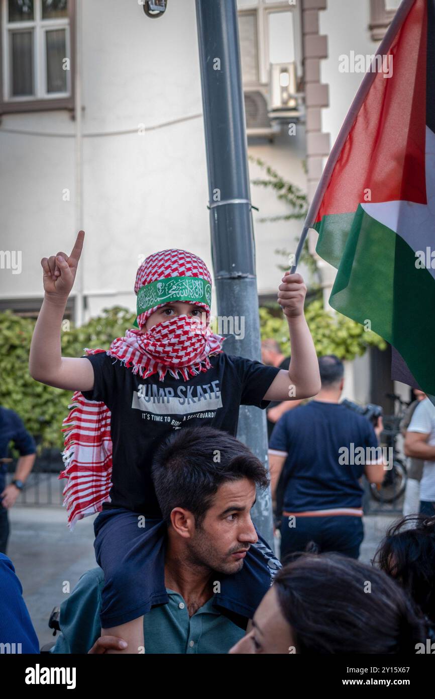 A child, with his face covered with a keffiyeh, the symbolic ...