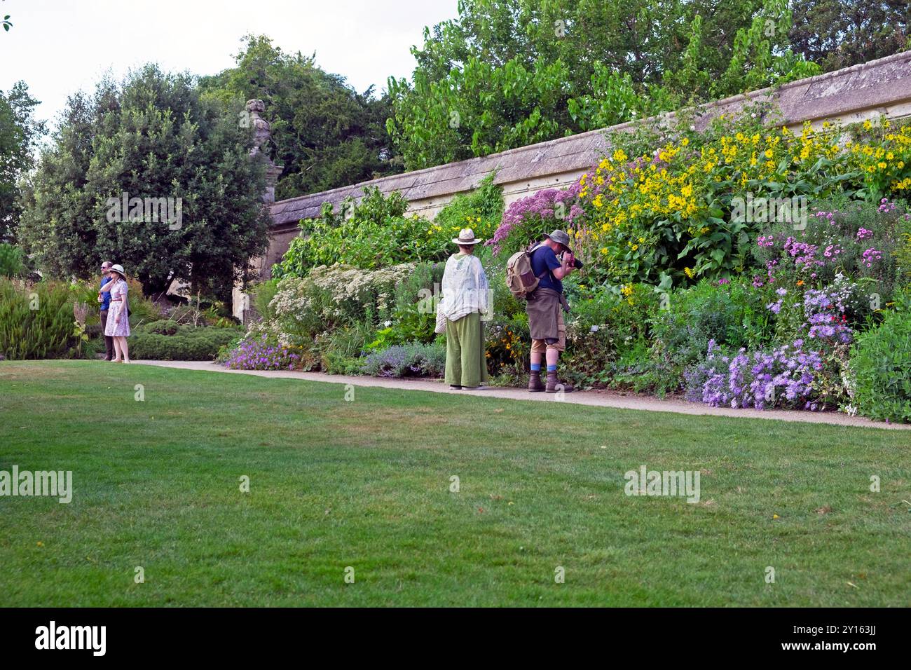 People looking at herbaceous border and photographer in summer at ...
