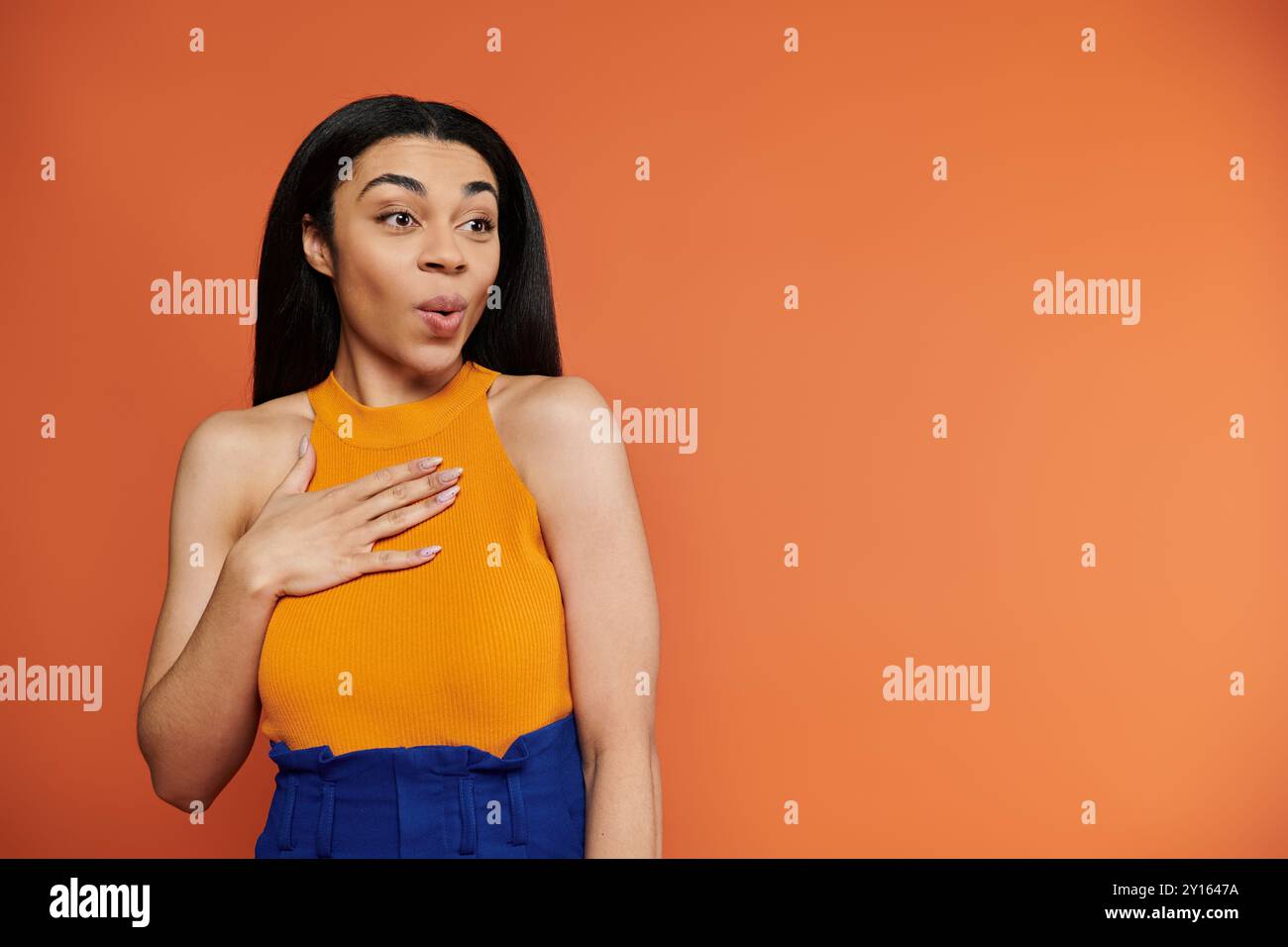 A stunning woman showcases a surprised expression with a hand on her ...