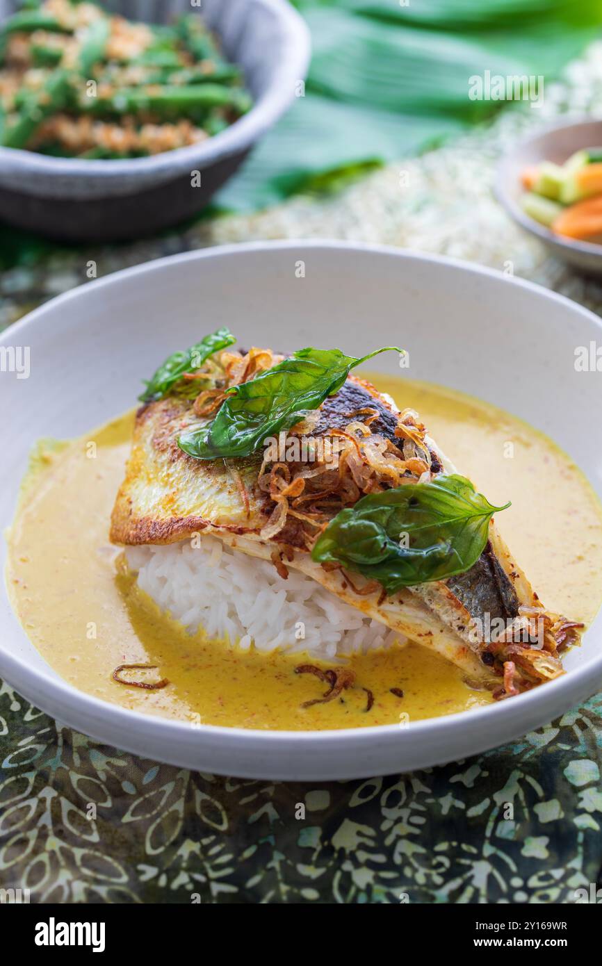 Indonesian curry with crispy sea bass and rice Stock Photo - Alamy