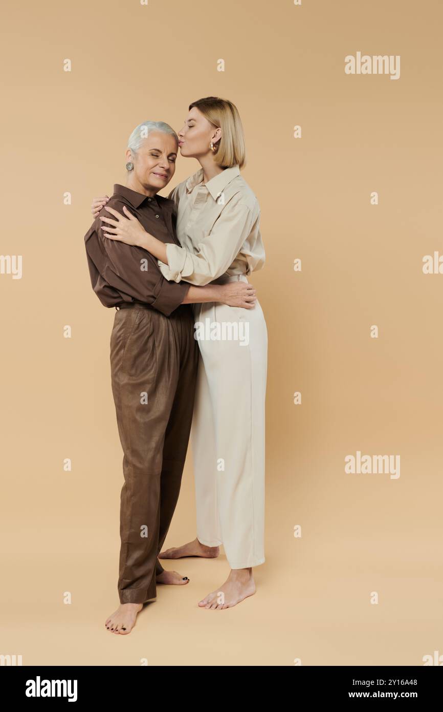 A mature woman is lovingly embraced by her adult daughter in a warm ...