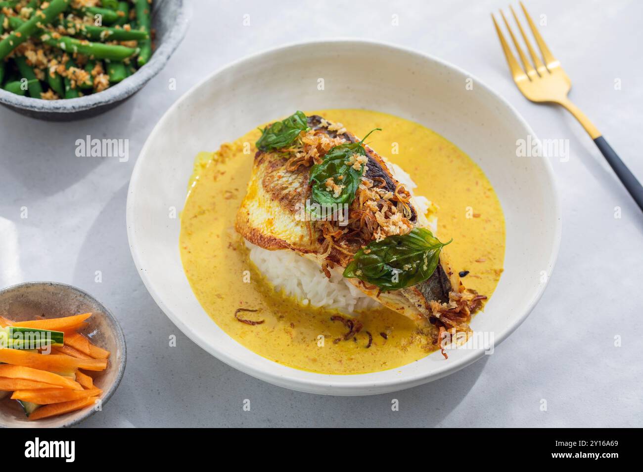 Indonesian curry with crispy sea bass and rice Stock Photo - Alamy