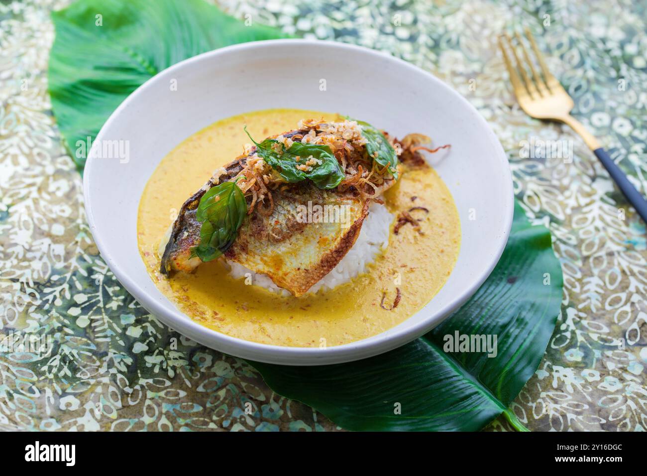 Indonesian curry with crispy sea bass and rice Stock Photo - Alamy